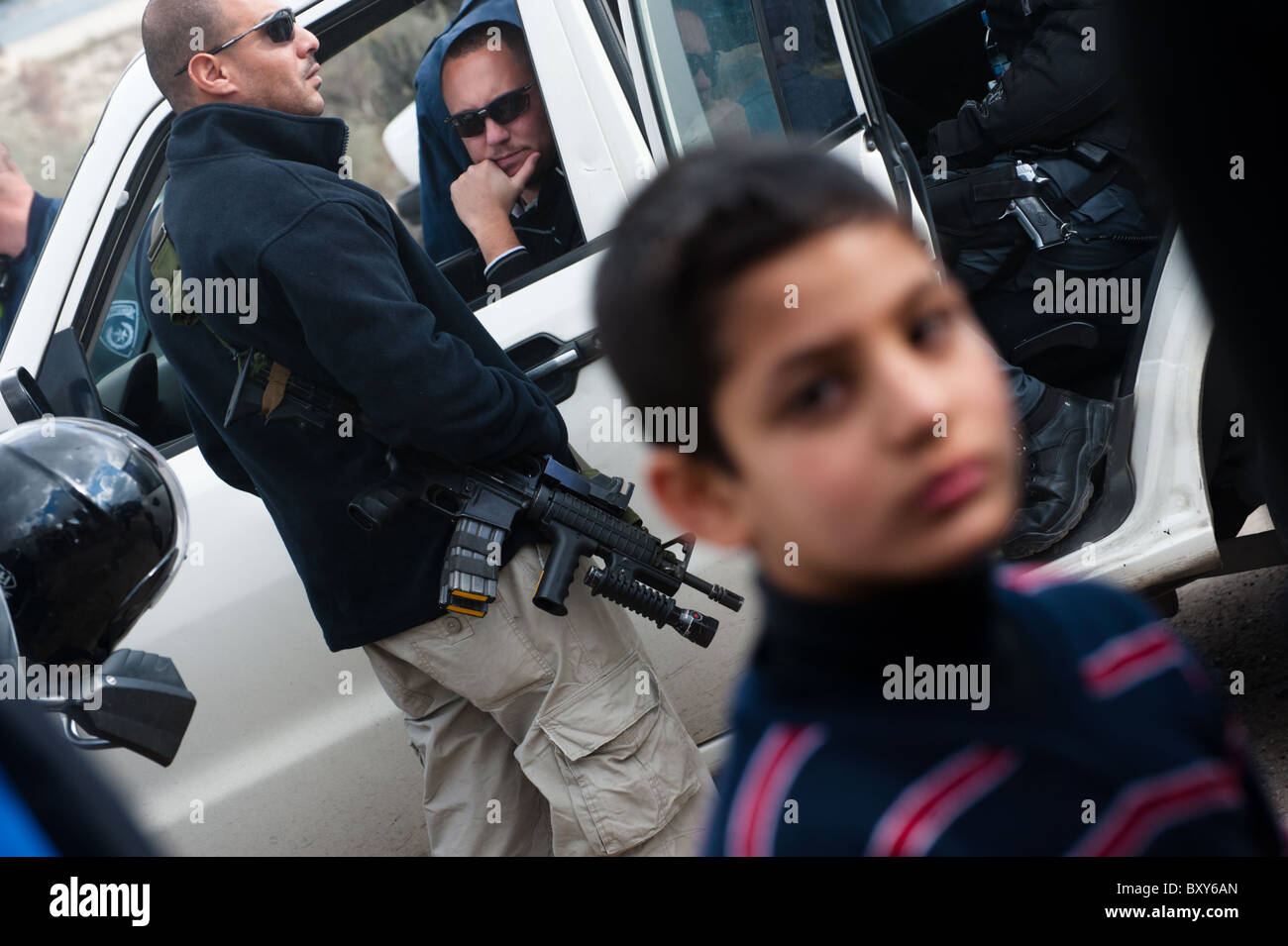 A Palestinian child watches Israeli security agents guarding a building ...