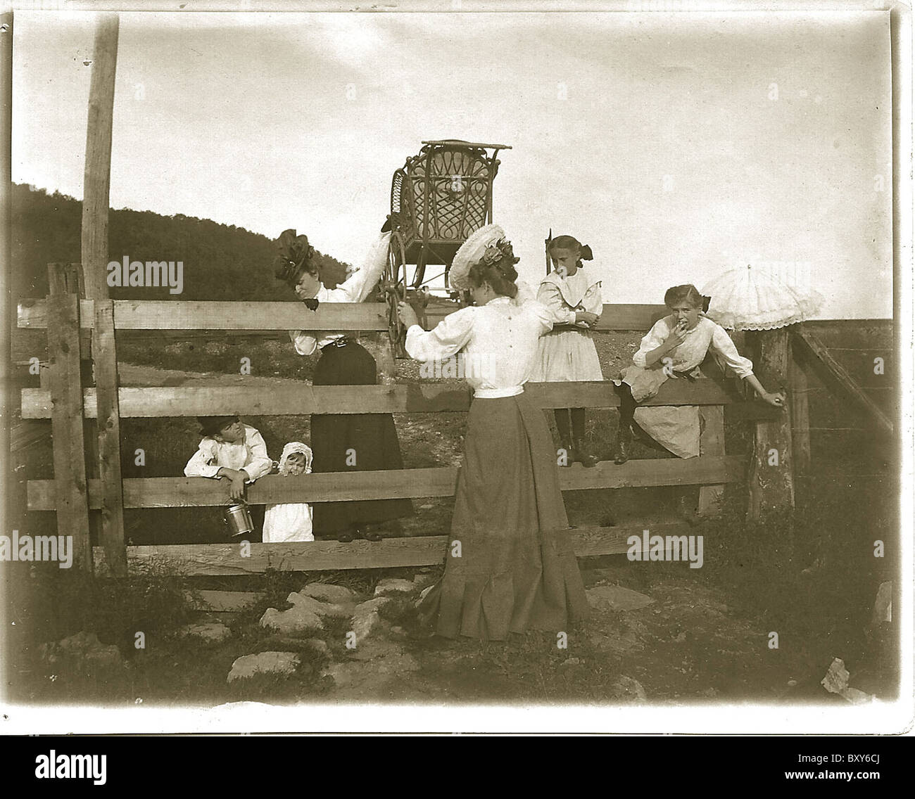 Strong women lift baby carriage over the fence coming home from the ...