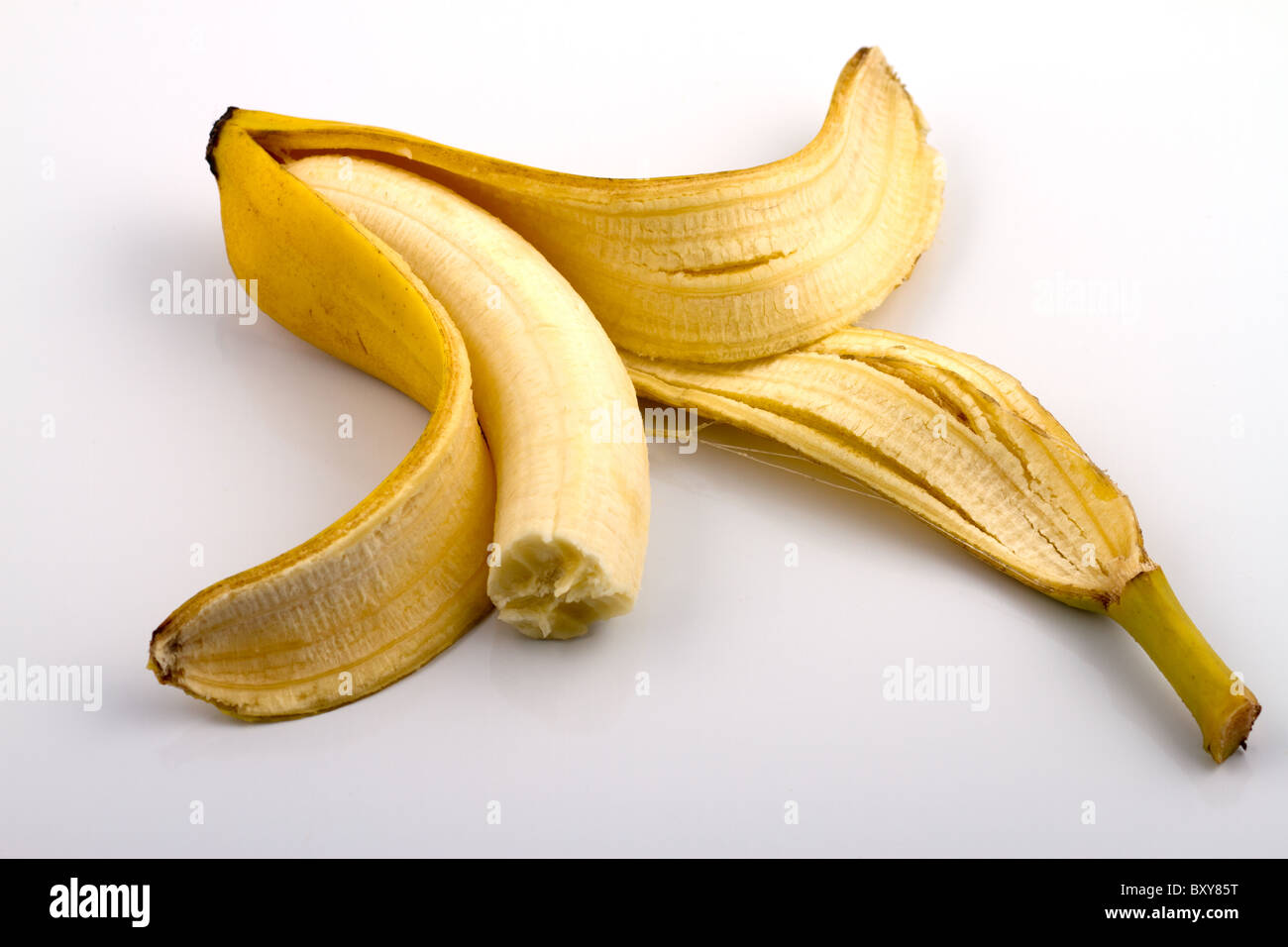 A peeled banana with bite marks on reflecting white background Stock ...