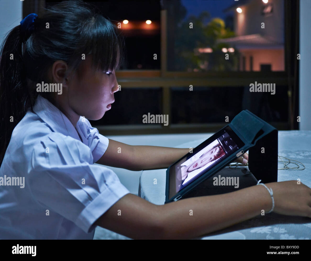 iPad child. Young Thai girl using an iPad at home. Thailand S. E. Asia ...
