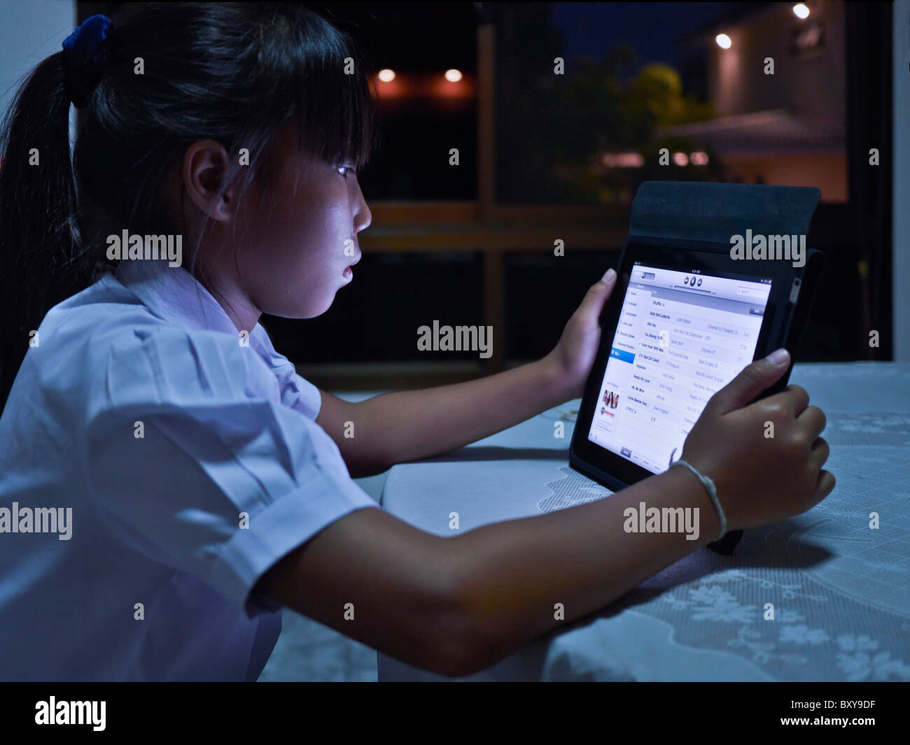 iPad child. Young Thai girl using an iPad at home. Thailand S. E. Asia ...