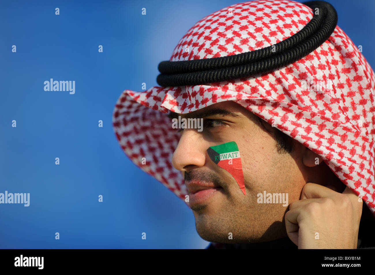 A fan of Kuwait with a painted national flag on his face Soccer - Asian ...
