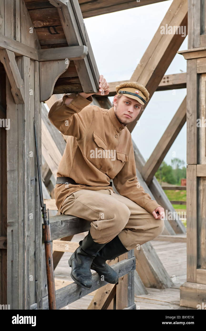 Soldier with a gun sitting next to the sentry. Costume accord the times ...