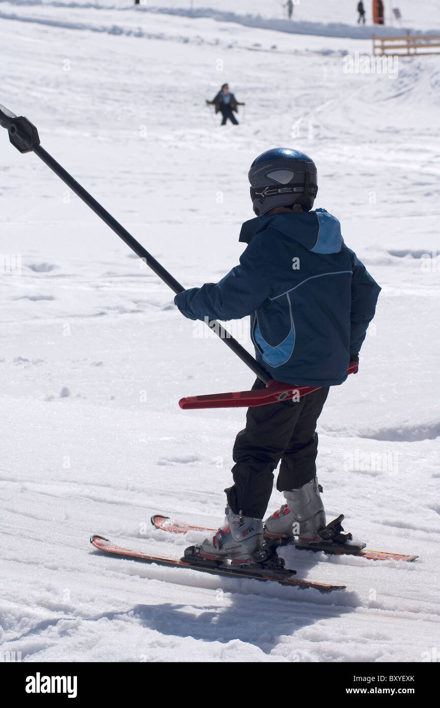 young boy holding on to a button lift Stock Photo - Alamy