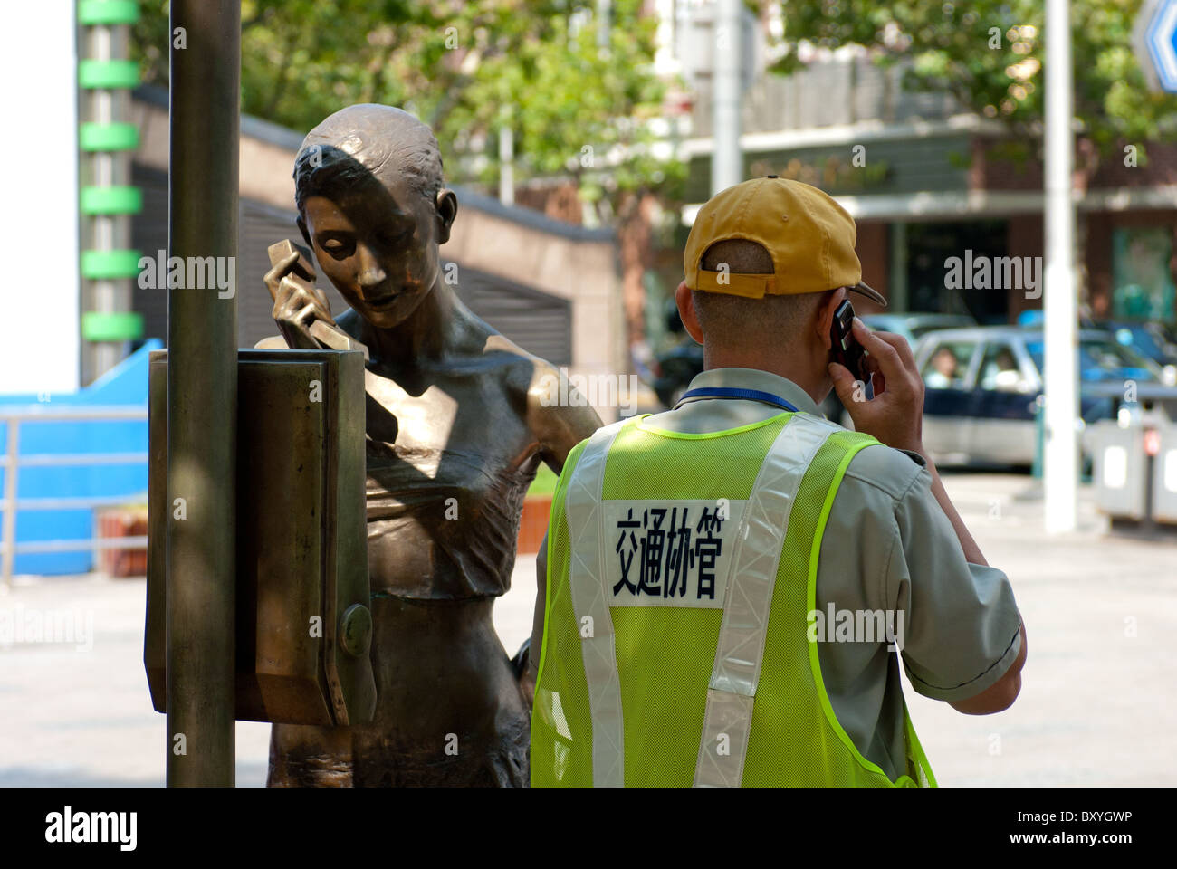 Street scene of a "traffic helper" talking on his mobile phone besides ...