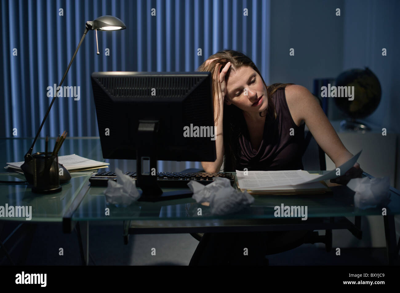 Woman working late in office Stock Photo - Alamy