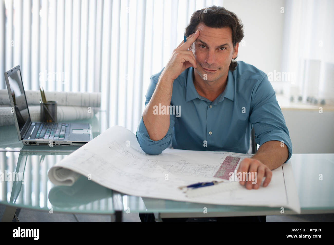 Architect with blueprints in office Stock Photo - Alamy