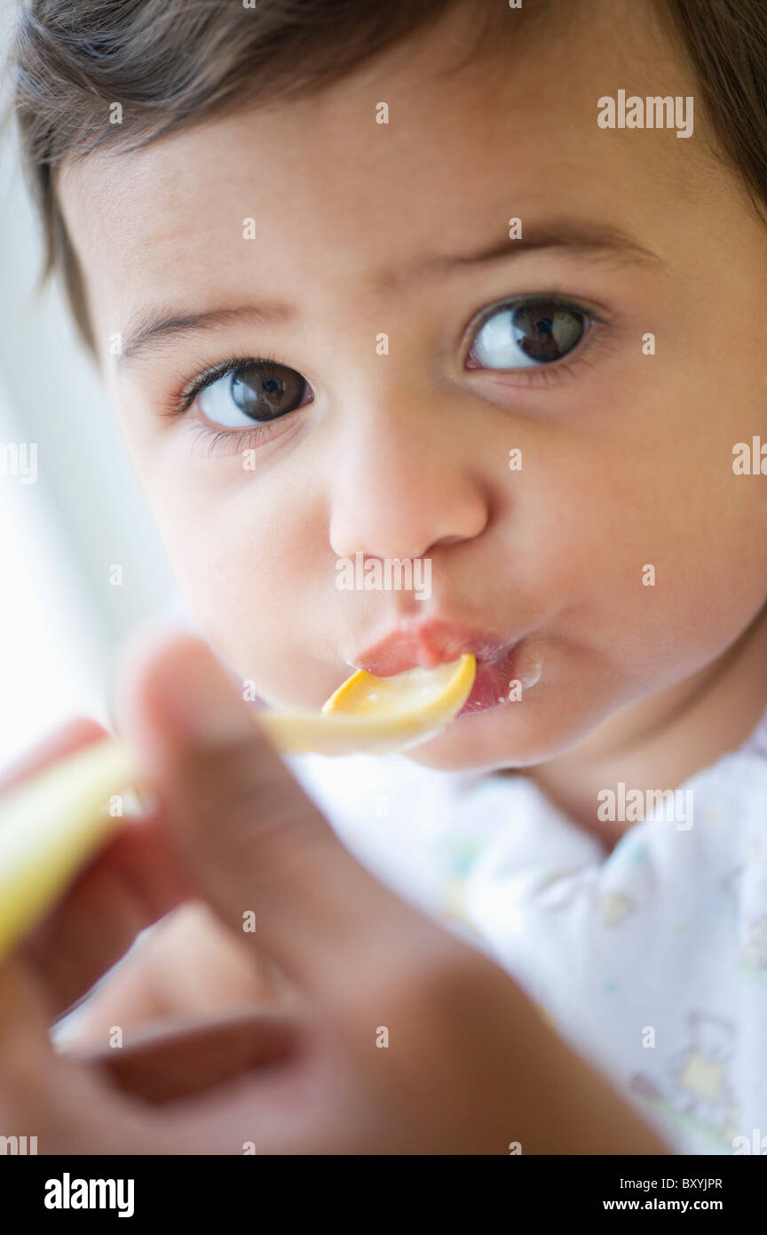 Baby girl eating from plastic spoon Stock Photo - Alamy