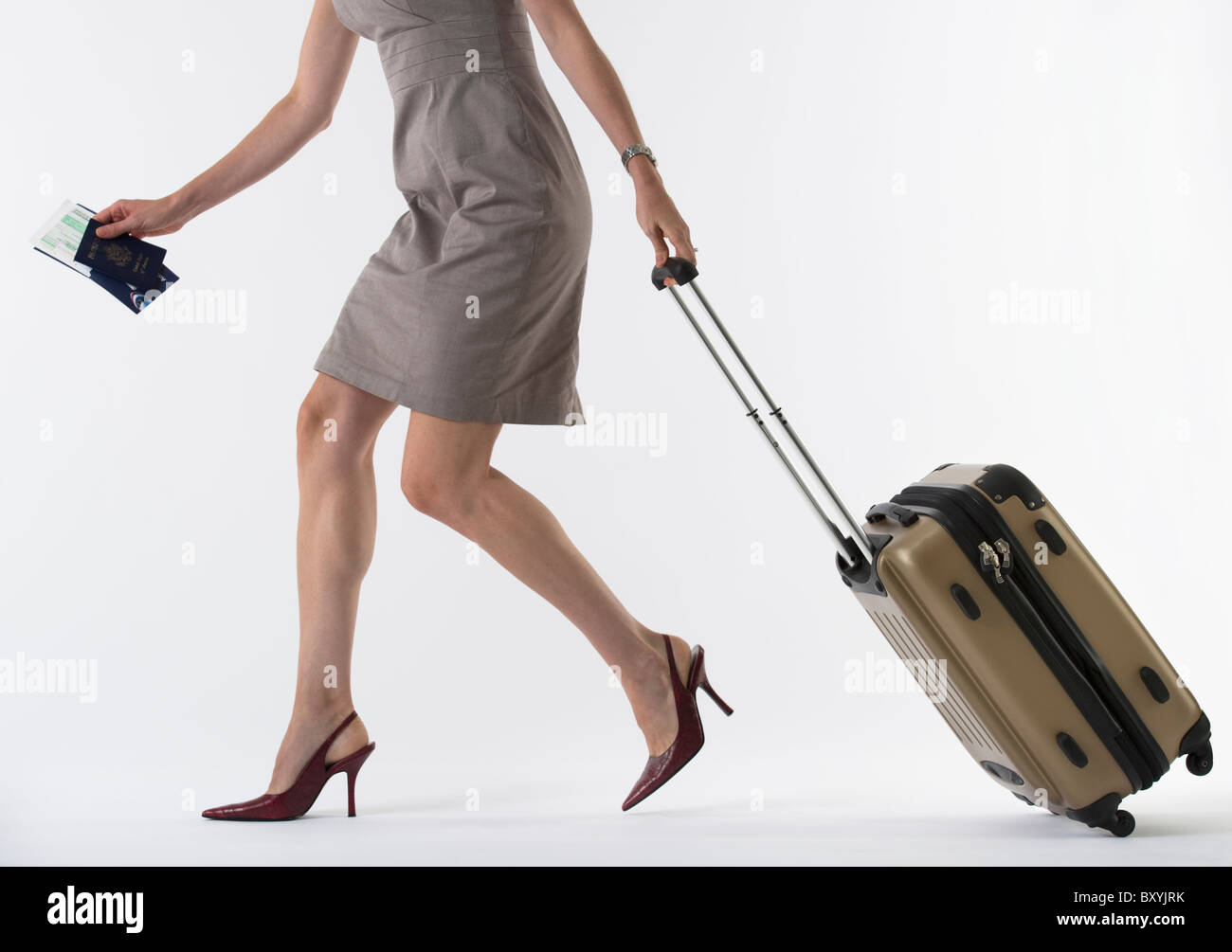 Young woman with suitcase, studio shot Stock Photo - Alamy