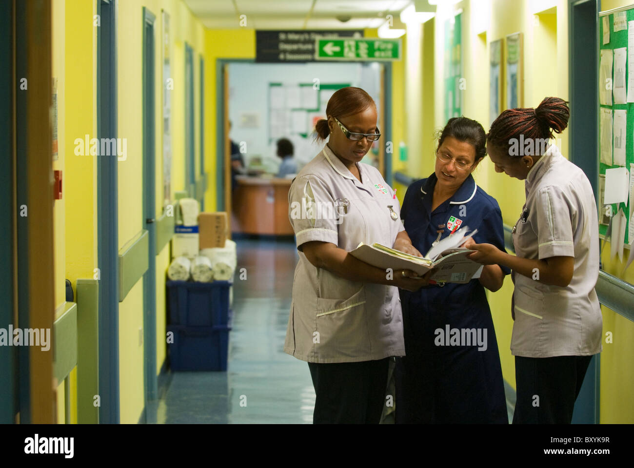 Three nurses discuss notes in a hospital corridor UK Stock Photo - Alamy