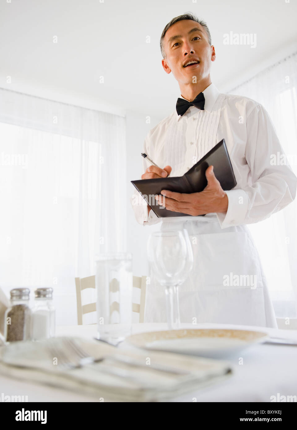 Waiter taking order and looking at camera Stock Photo - Alamy