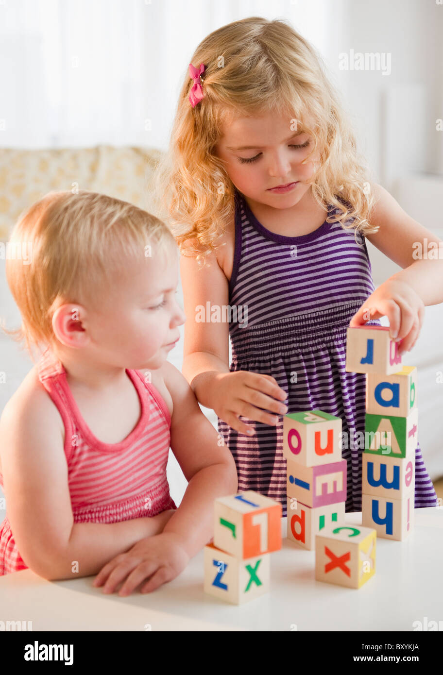Girls playing with blocks and looking at camera Stock Photo - Alamy