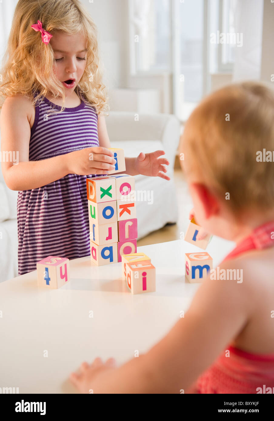Girls playing with blocks and looking at camera Stock Photo - Alamy
