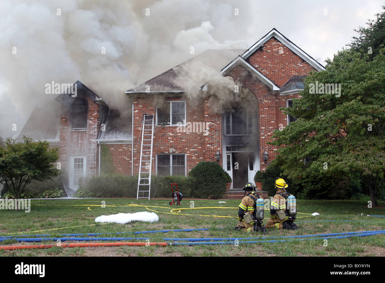 Fire fighters put out a blaze in a 2 story house Stock Photo - Alamy