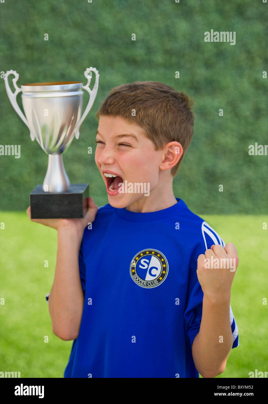 Boy holding trophy and cheering Stock Photo - Alamy