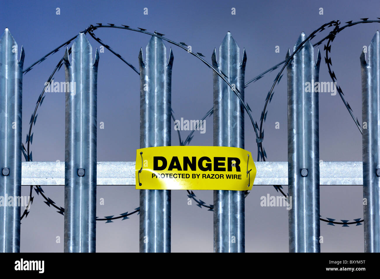 Danger sign warning of concertina razor wire mounted onto galvanized ...