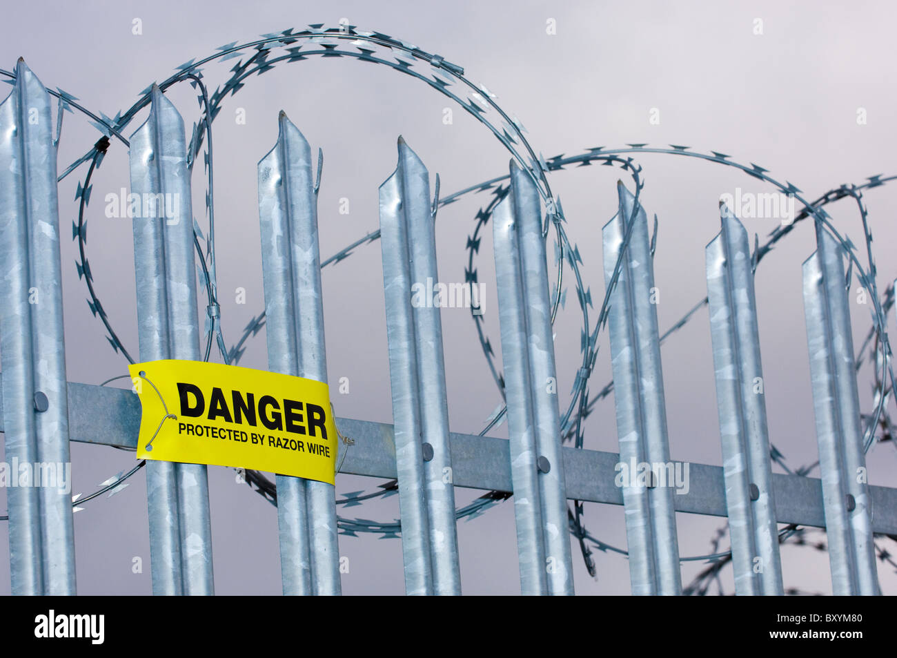 Danger sign warning of concertina razor wire mounted onto galvanized ...
