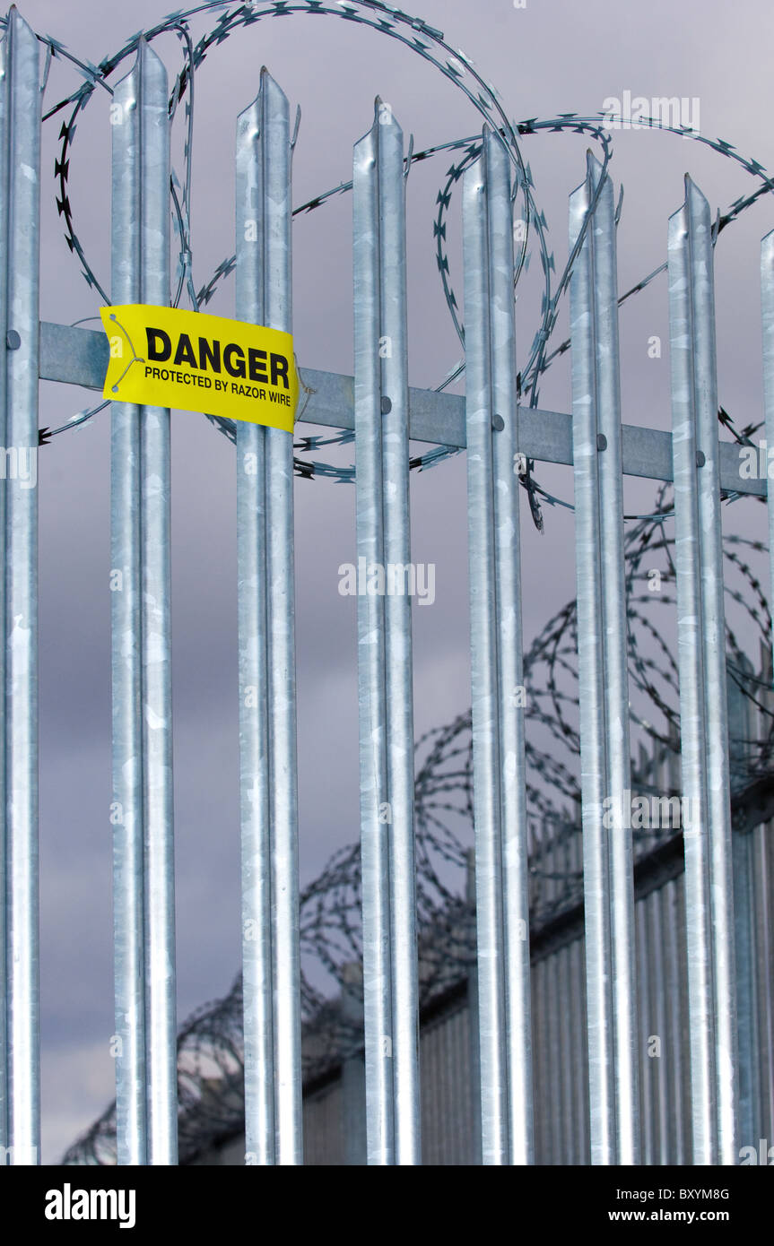 Danger sign warning of concertina razor wire mounted onto galvanized ...