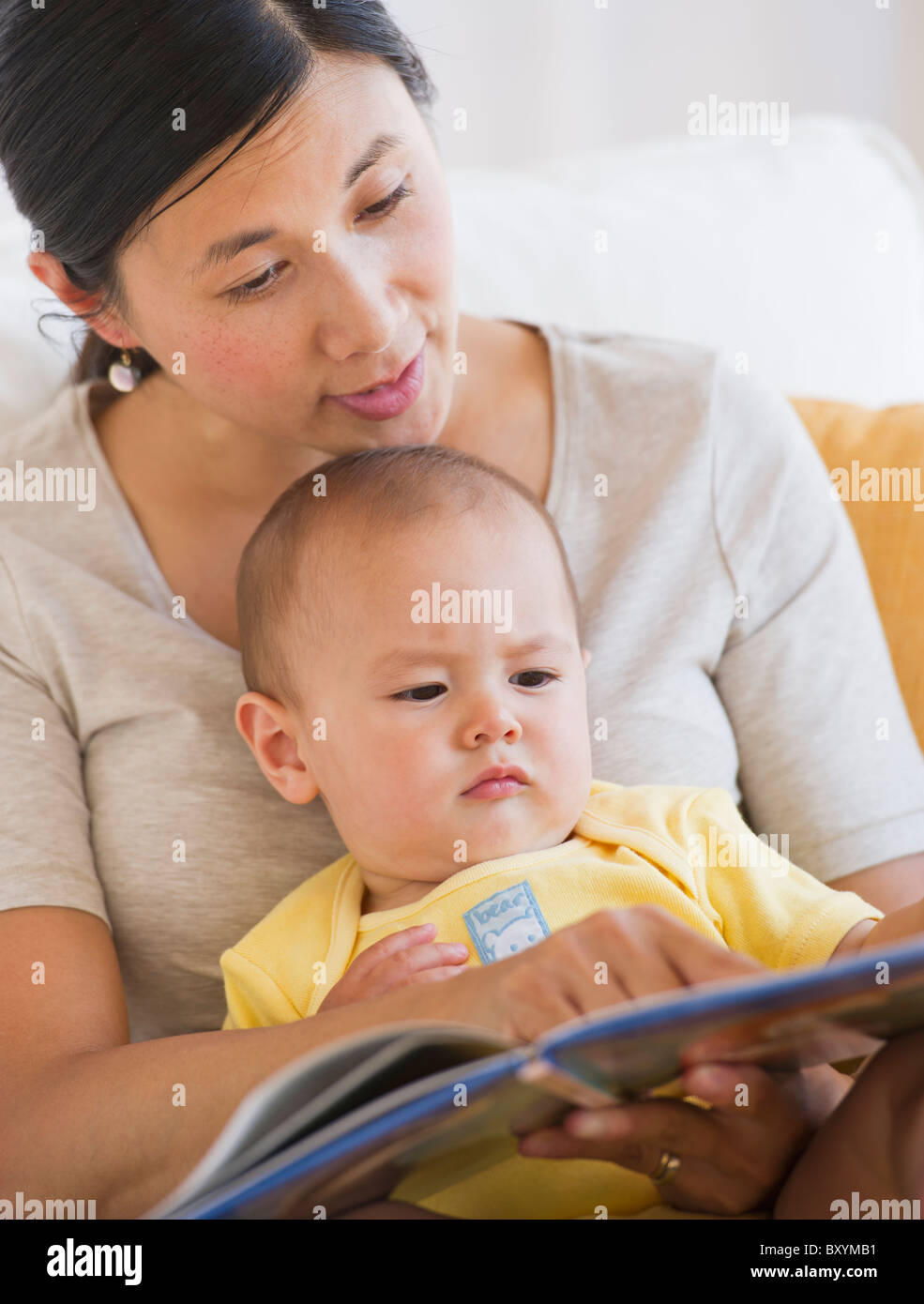 Mother reading book to her son Stock Photo - Alamy