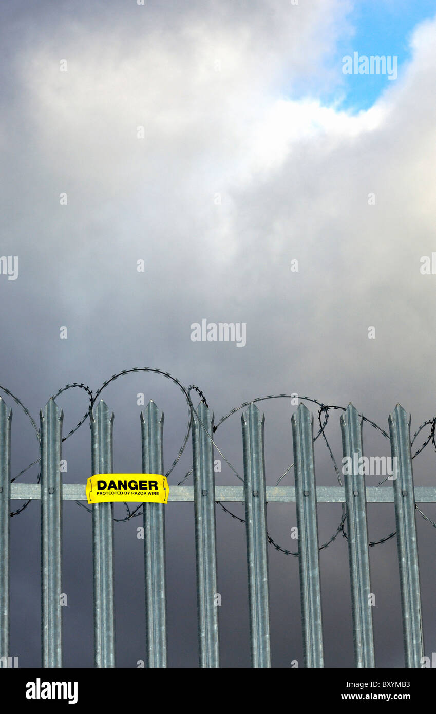 Danger sign warning of concertina razor wire mounted onto galvanized ...