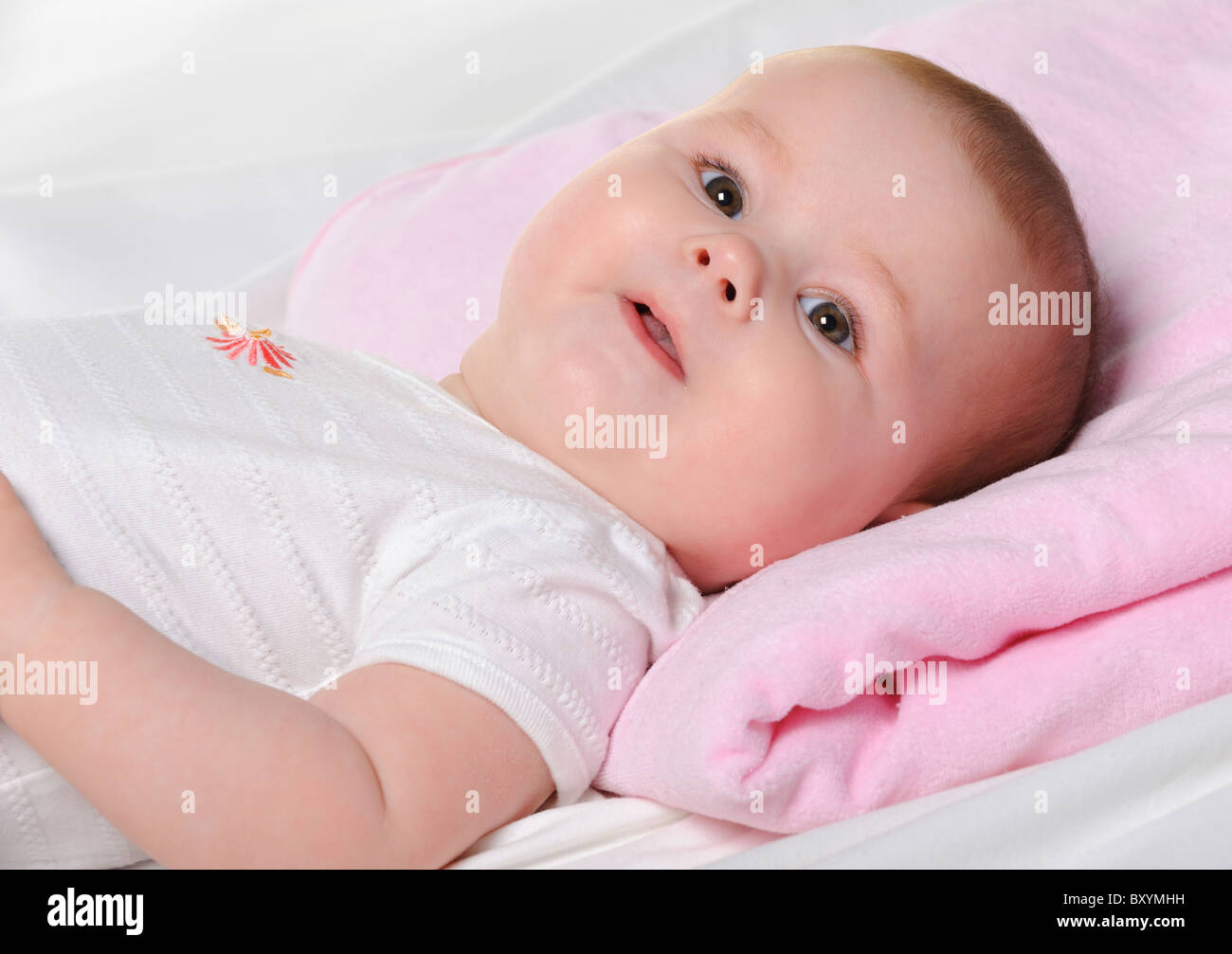 The baby lays. Age of 8 months. It is isolated on a white background ...