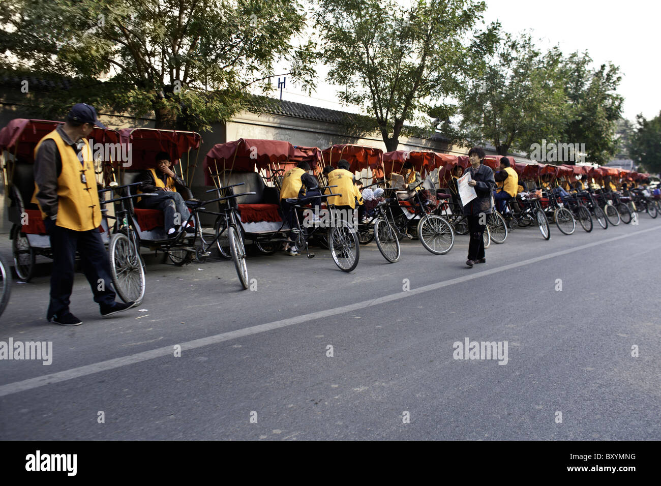 CHINA, BEIJING: Pedicab drivers pass the time as they wait for ...