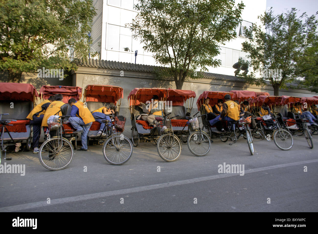 CHINA, BEIJING: Pedicab drivers pass the time as they wait for ...