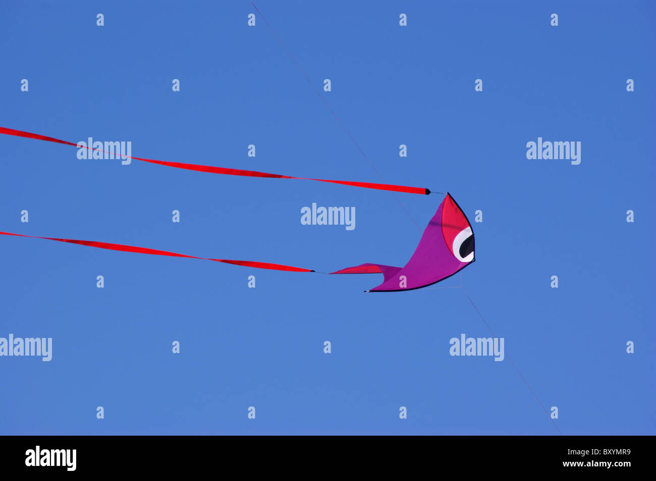 Fish-shaped kite against a vivid blue sky Stock Photo - Alamy