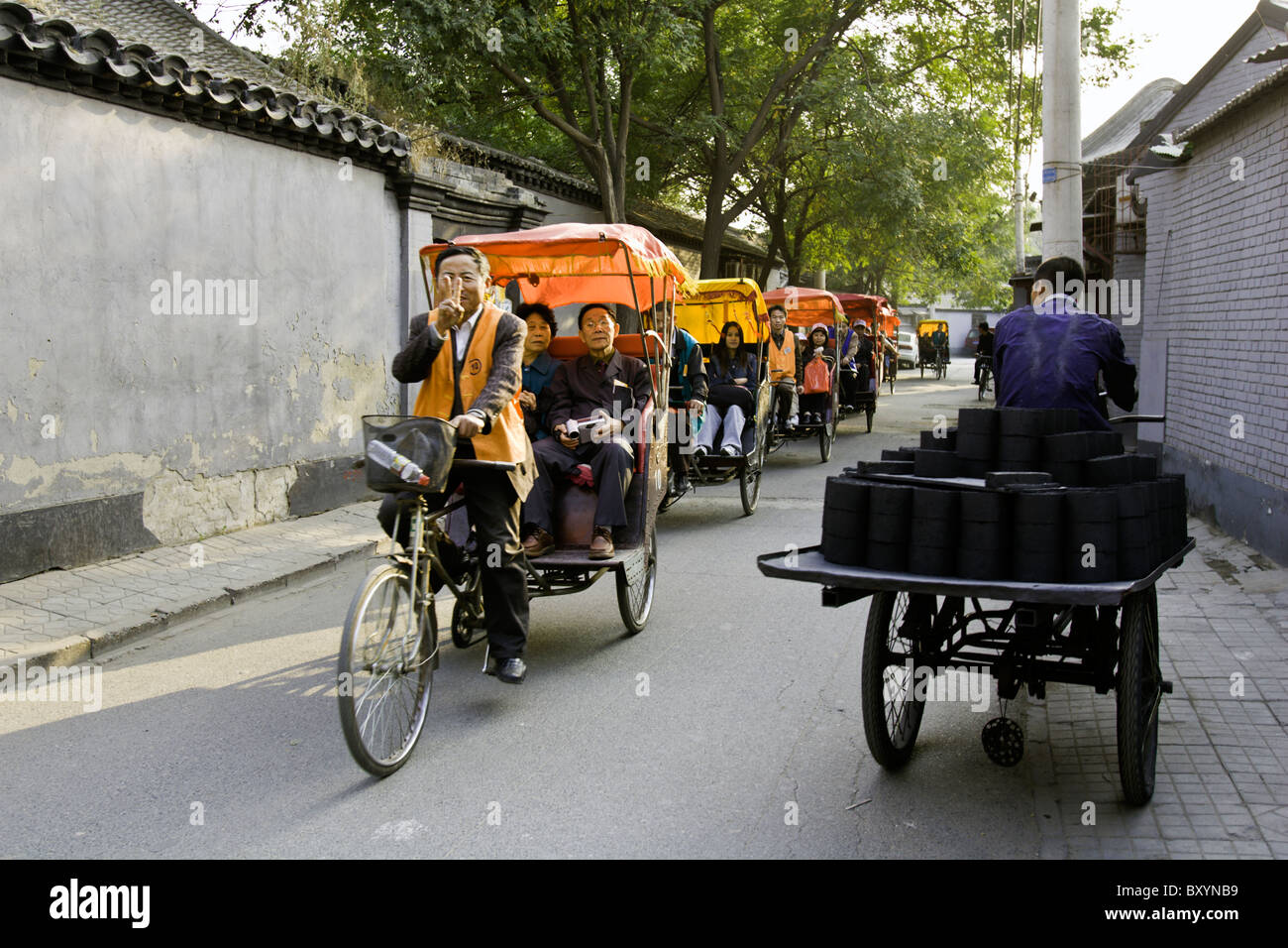 CHINA, BEIJING: Pedicab driver gives the peace sign as pedicabs ...