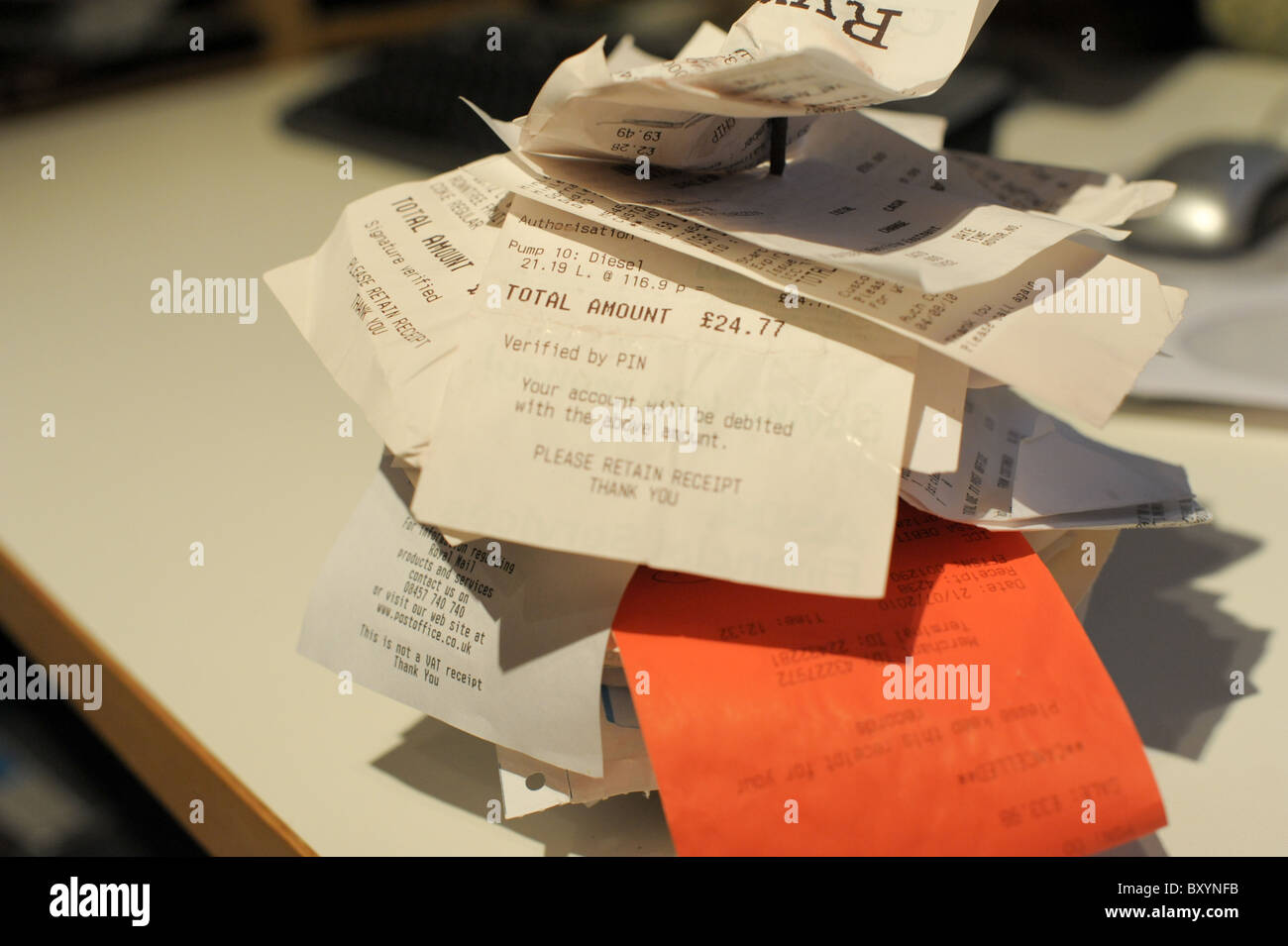 Receipts and bills on a spike in an office on a desk ready to be dealt ...