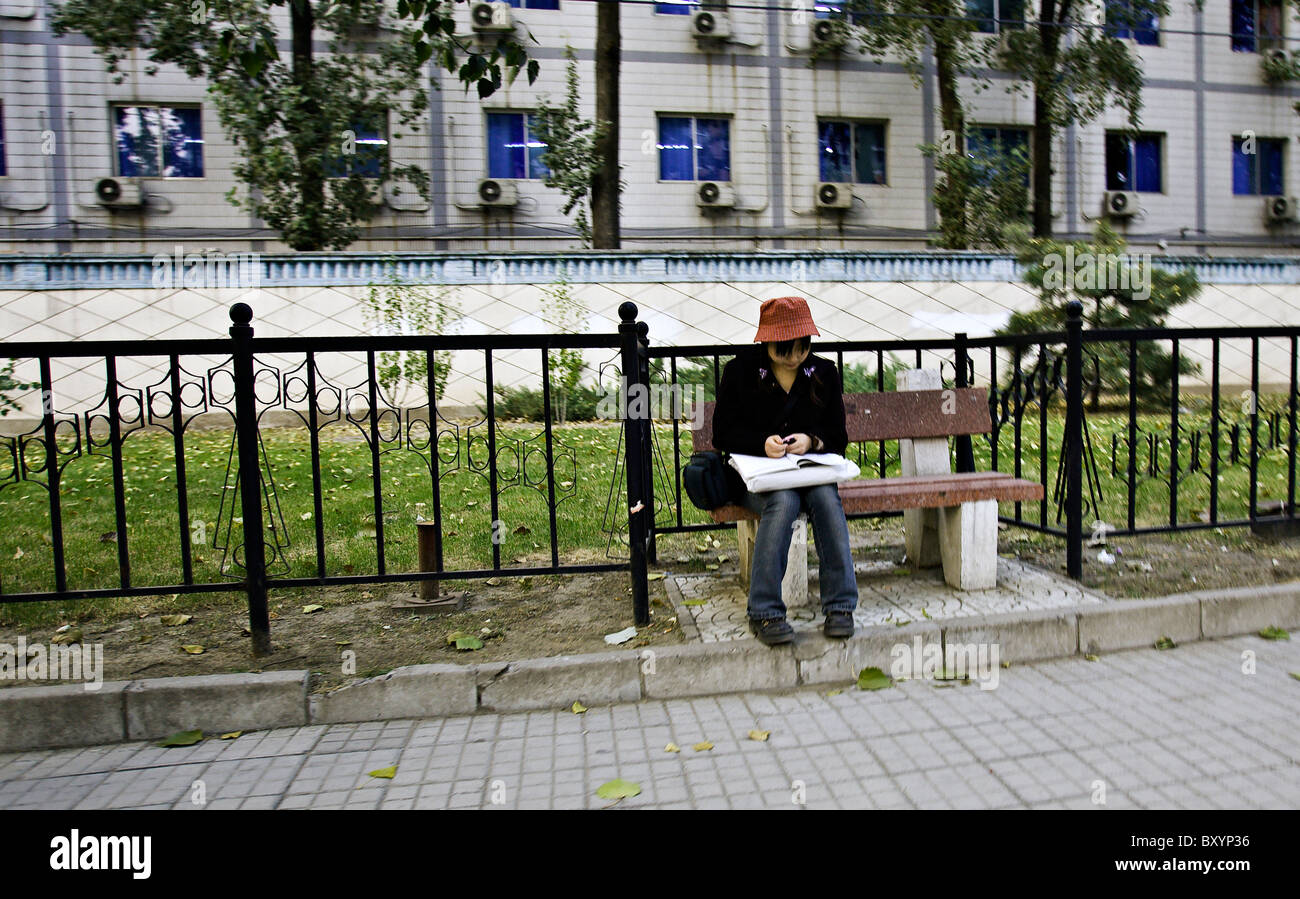 CHINA, BEIJING: Young Chinese college student studies her lesson on a ...