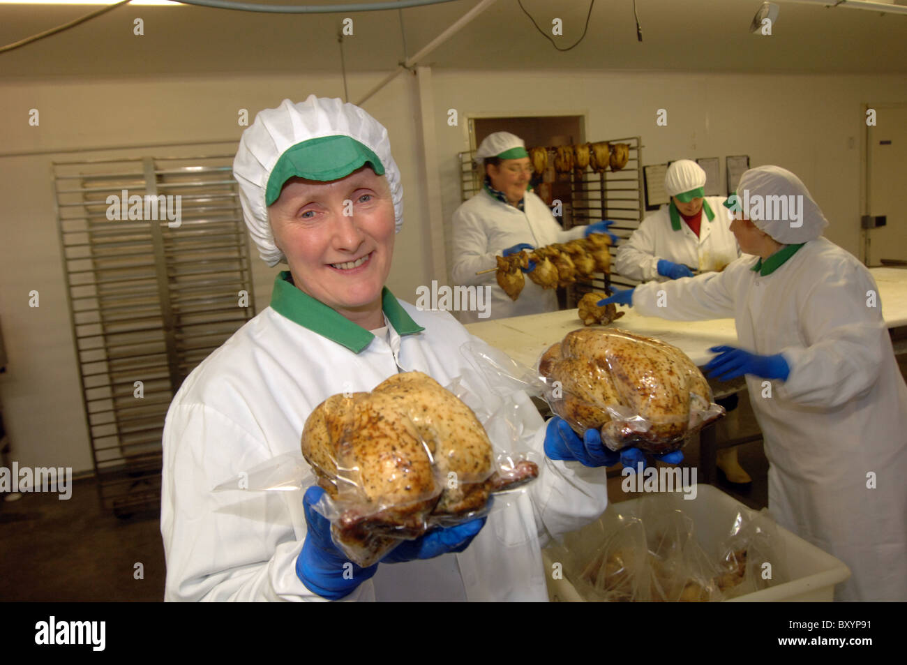 Adult female factory worker preparing chickens Stock Photo - Alamy