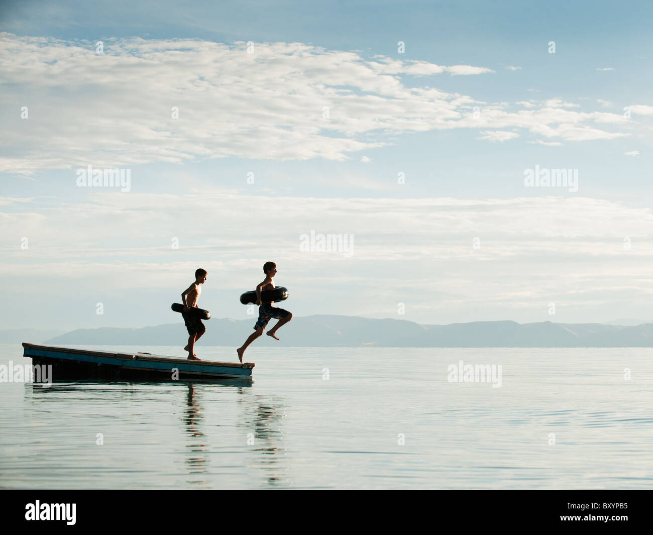 Boys jumping from raft Stock Photo - Alamy