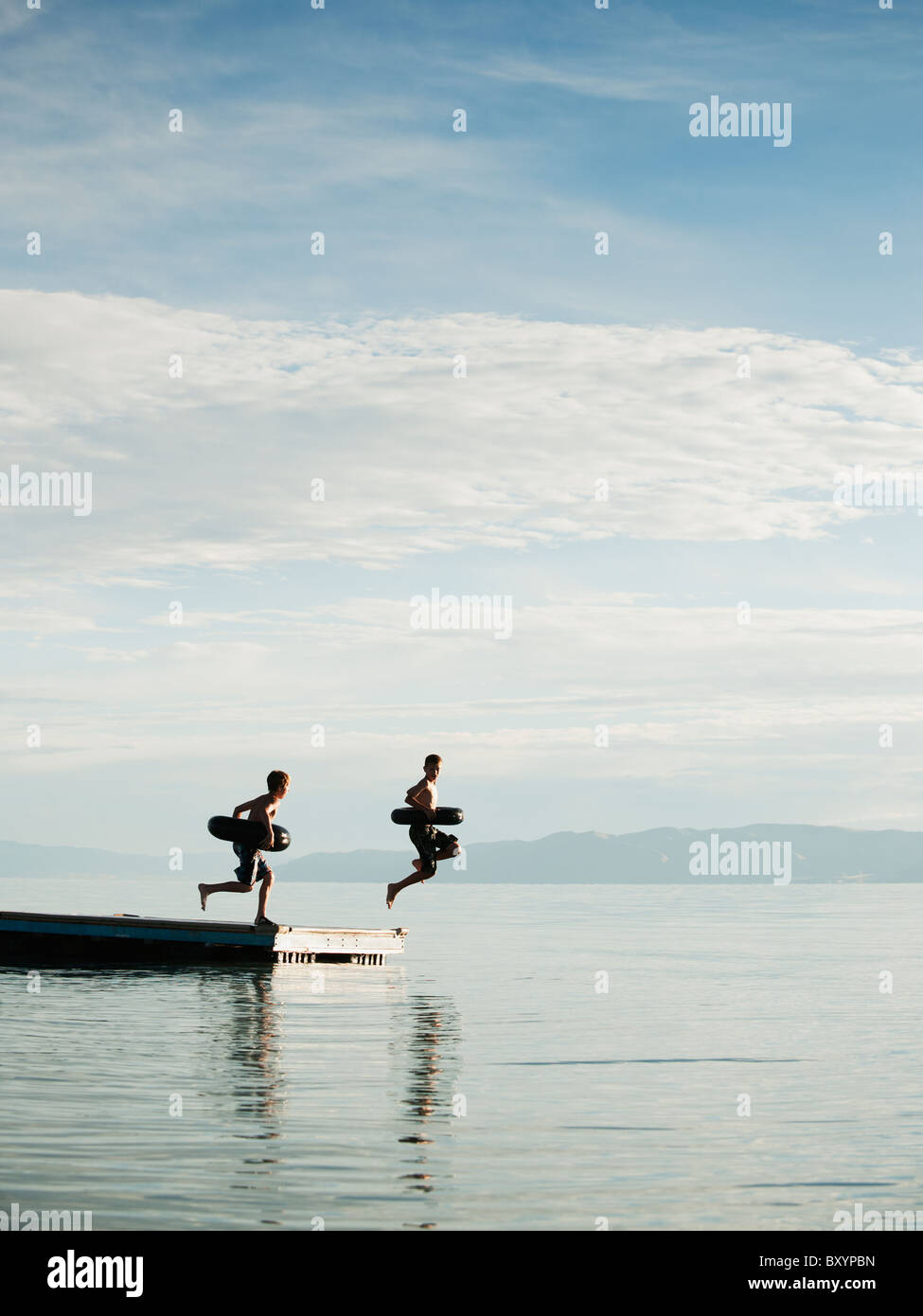 Boys jumping from raft Stock Photo - Alamy