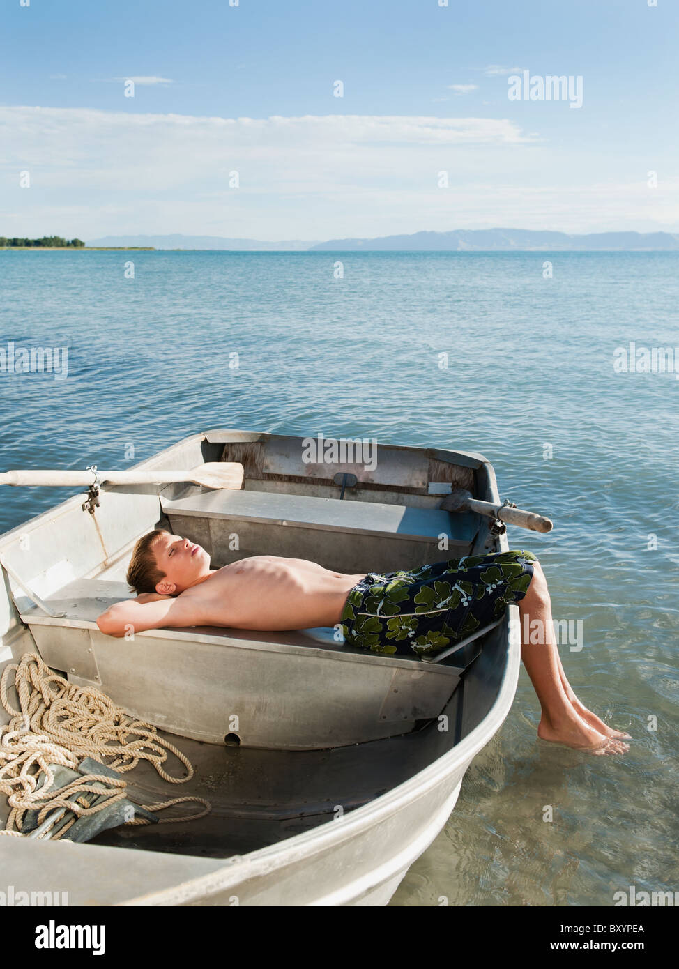 Boy resting on boat Stock Photo - Alamy