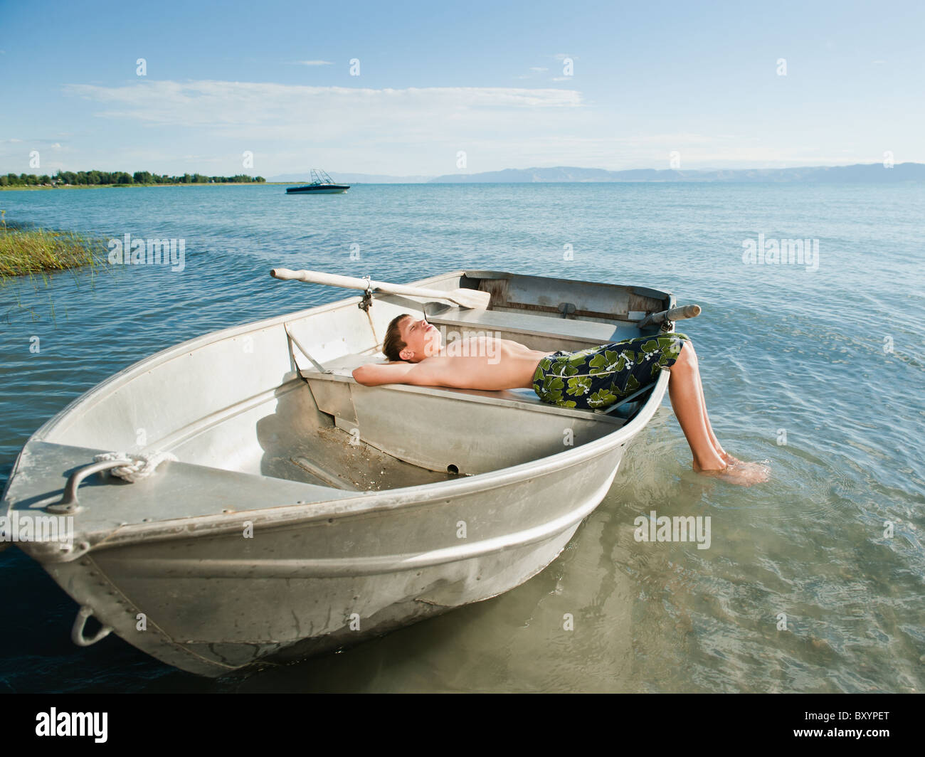 Boy resting on boat Stock Photo - Alamy