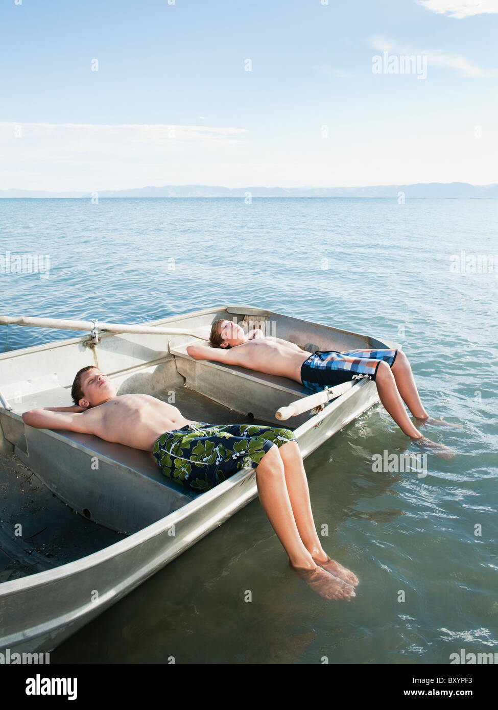 Boys resting on boat Stock Photo - Alamy