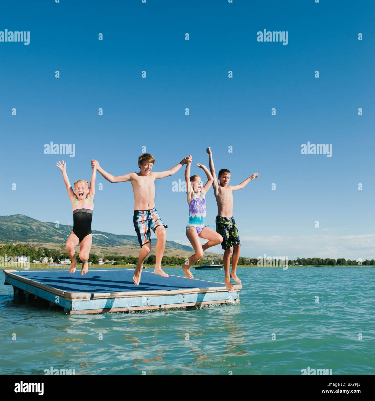 Kids playing on raft on lake Stock Photo - Alamy