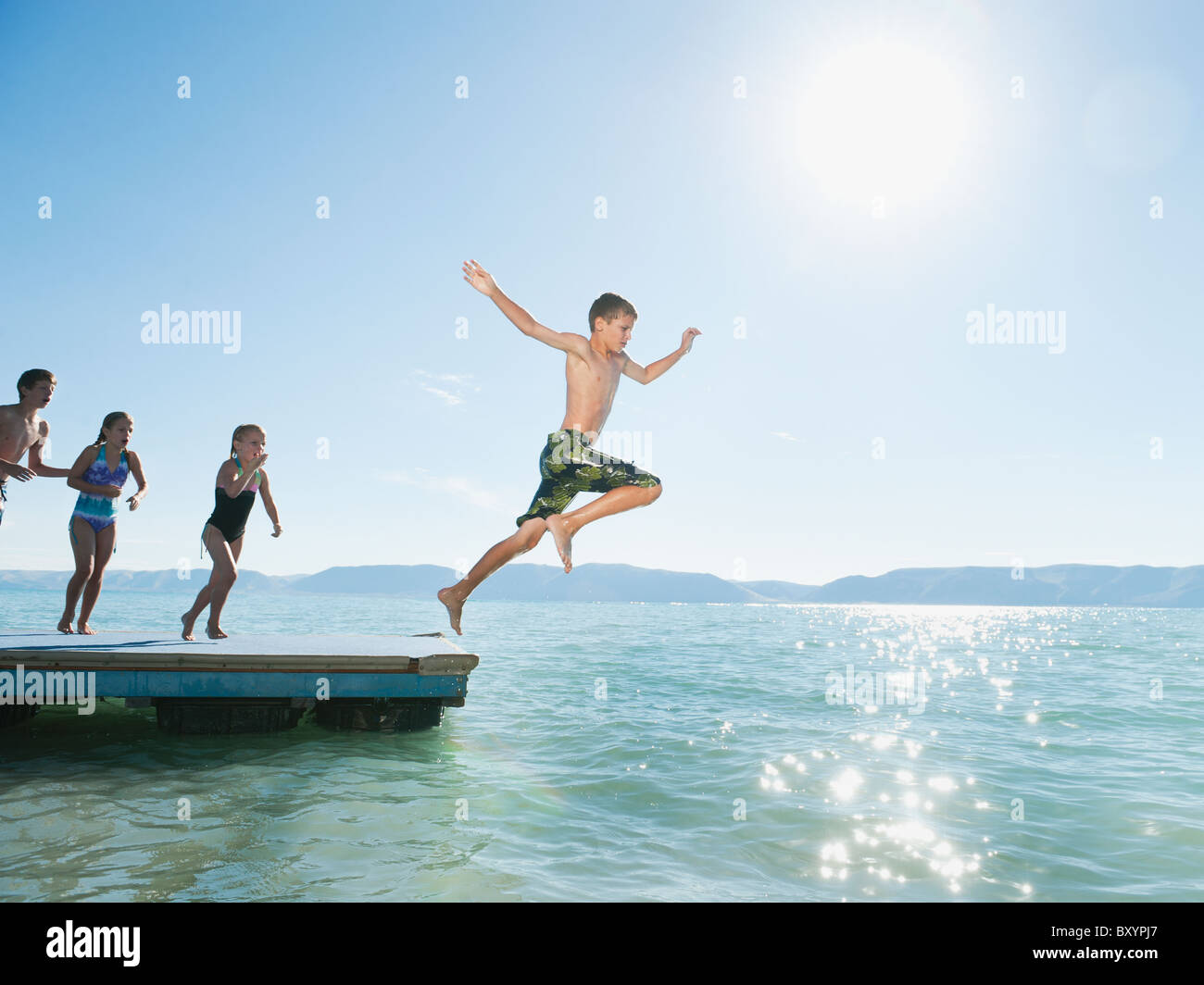 Kids playing on raft on lake Stock Photo - Alamy