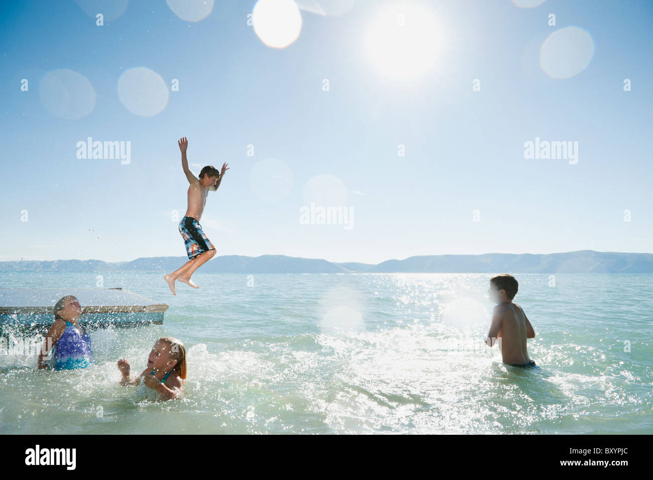 Kids playing on raft on lake Stock Photo - Alamy