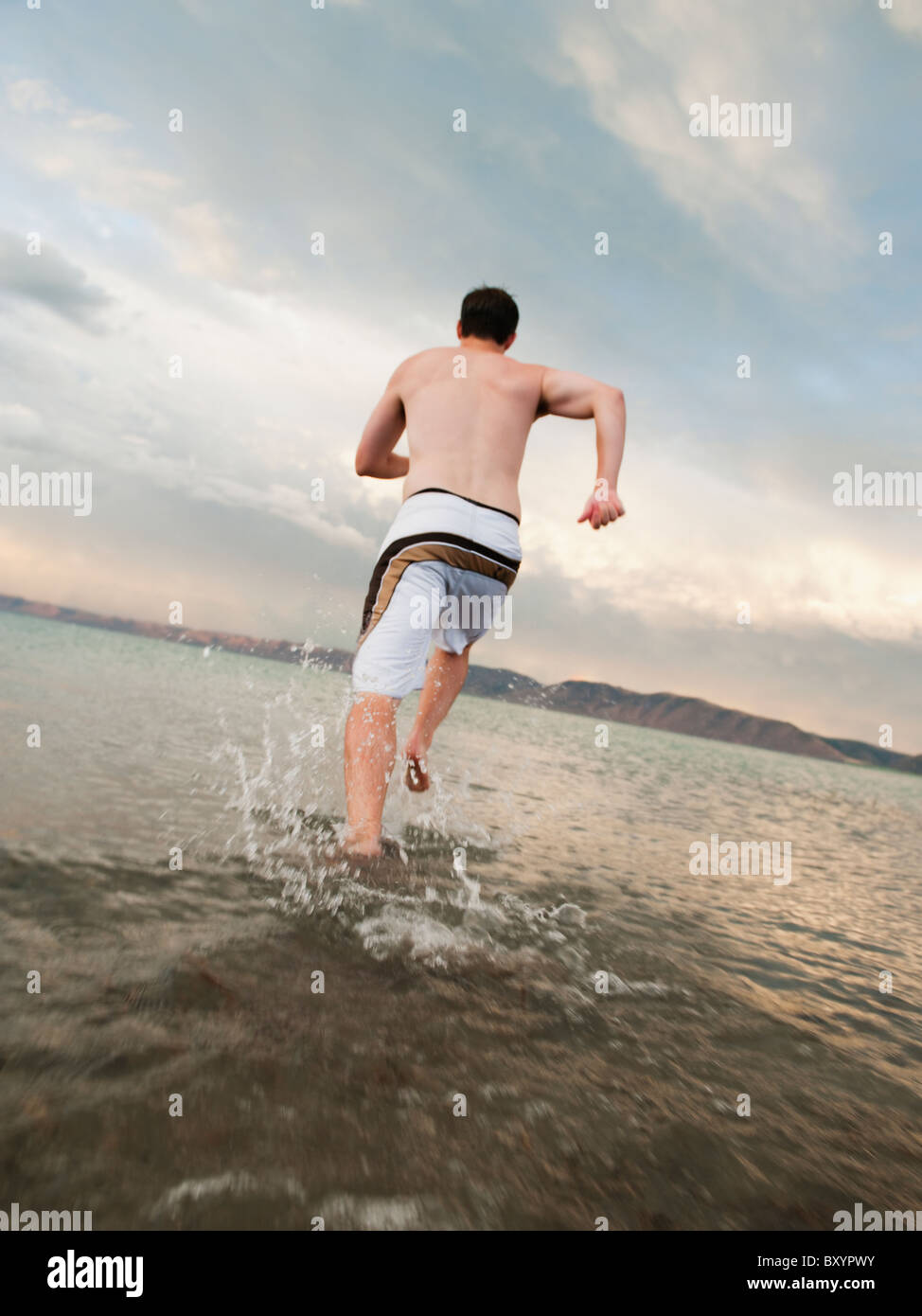 Man running on beach Stock Photo - Alamy