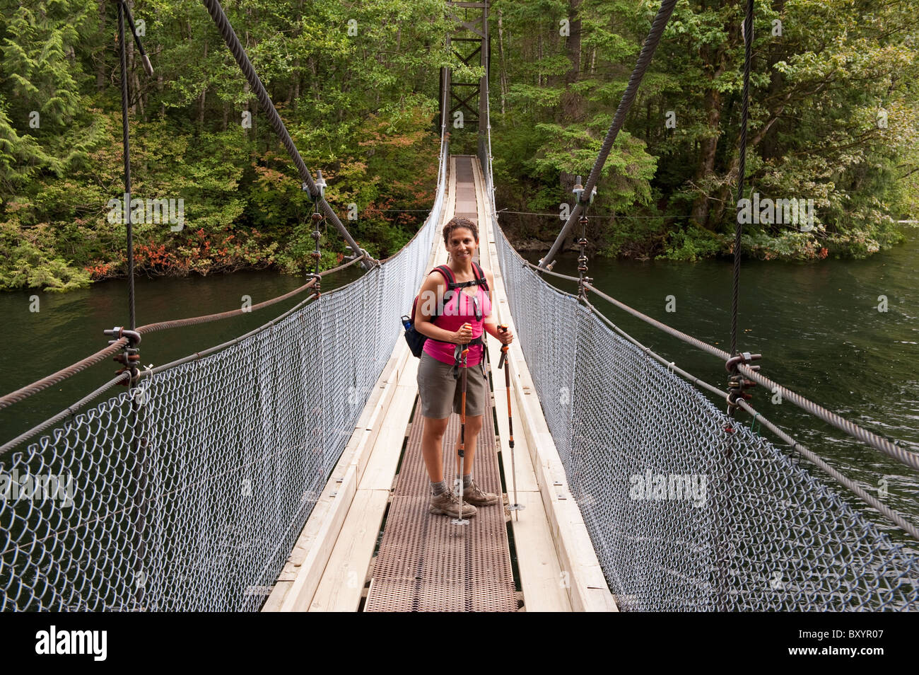 Hispanic woman hiking over bridge in woods Stock Photo - Alamy