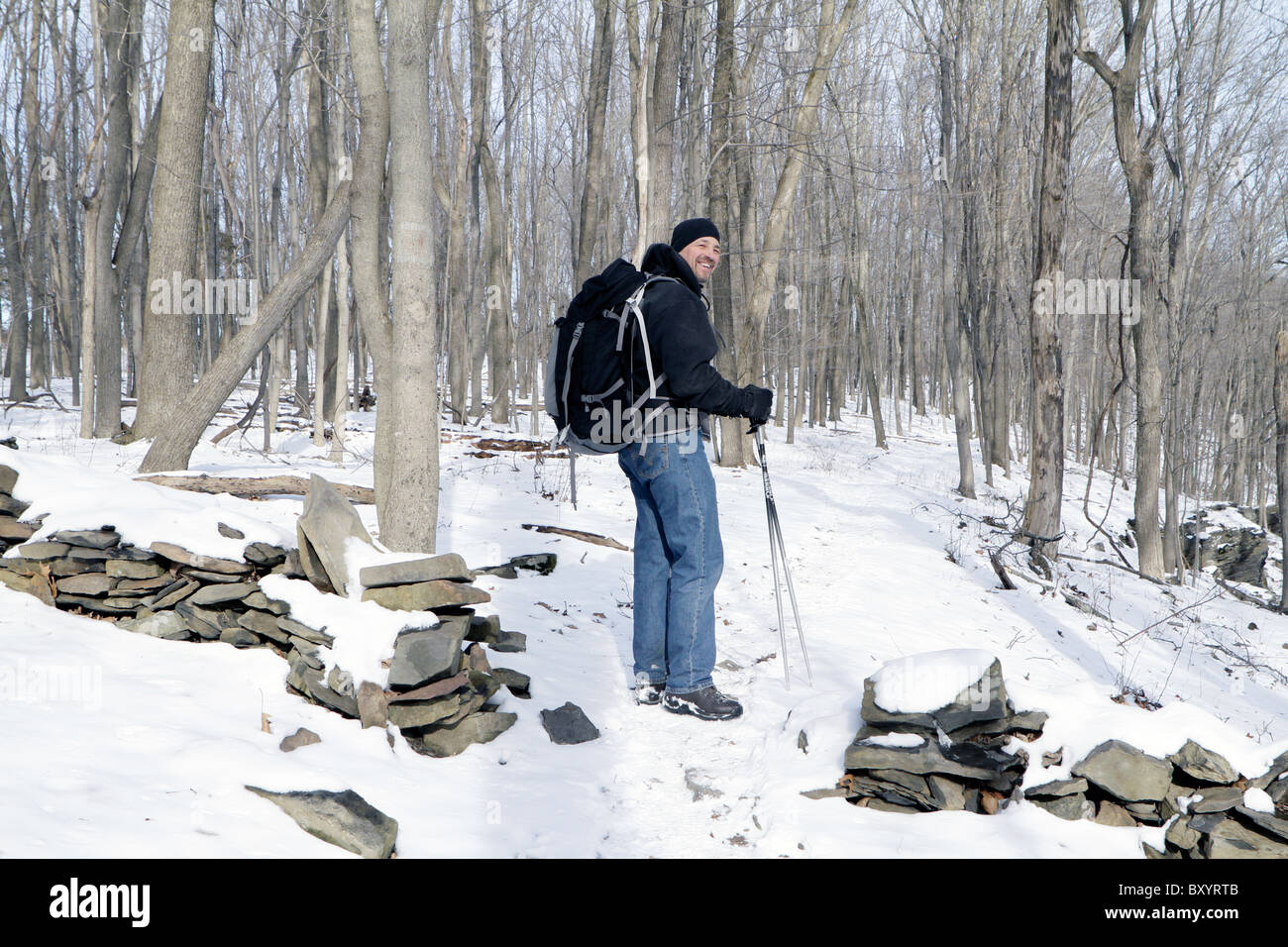 A Caucasian male man hiker hiking in winter on a snow covered trail ...