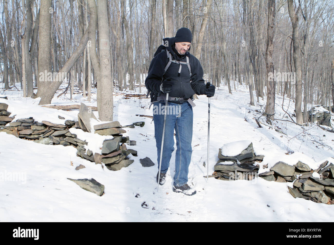 A Caucasian male man hiker hiking in winter on a snow covered trail ...