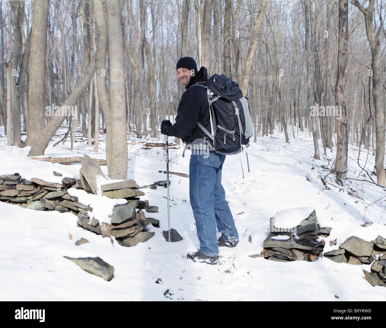 A Caucasian male man hiker hiking in winter on a snow covered trail ...