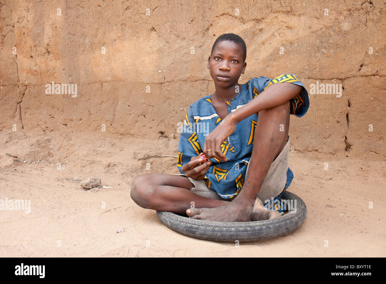 An African boy sits in a tire. His village participated in an income ...