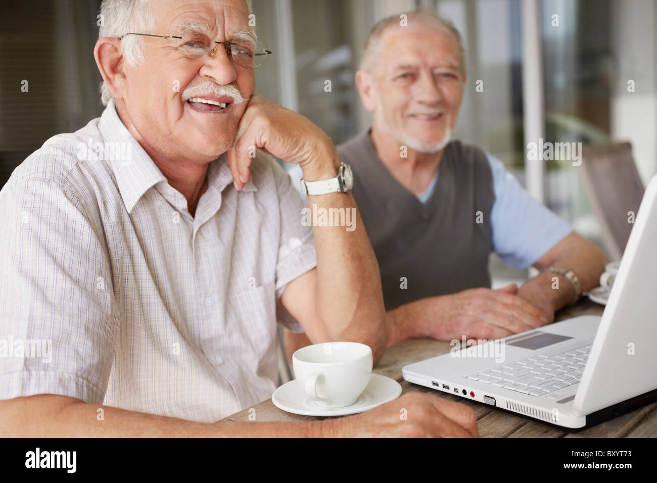 Two senior men relaxing at table Stock Photo - Alamy