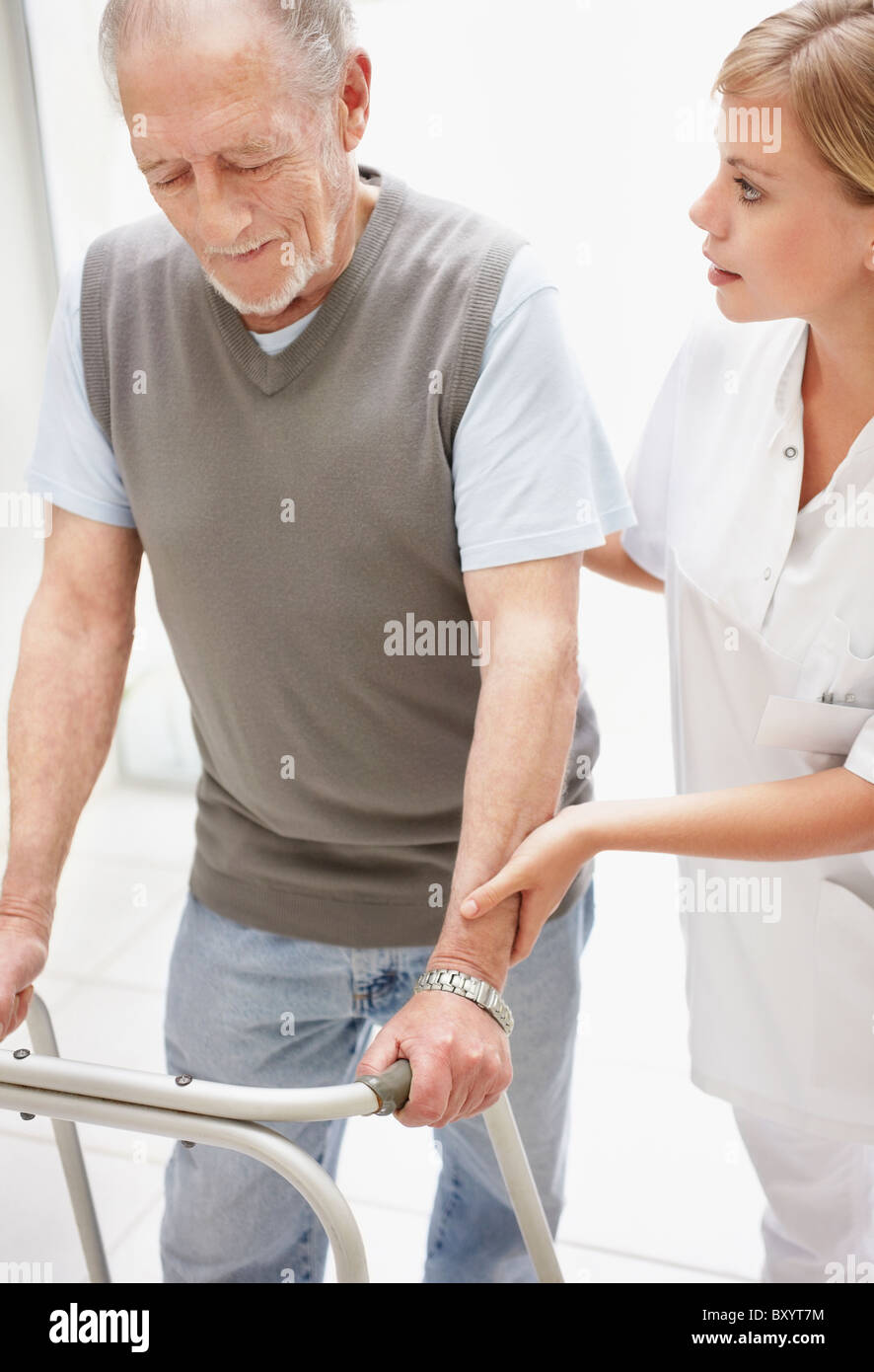 Nurse assisting patient in corridor of clinic Stock Photo - Alamy