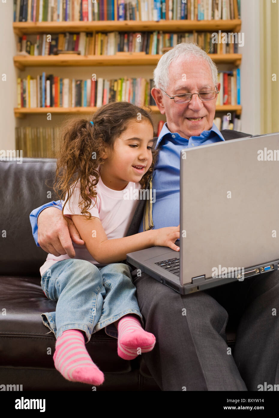 grandparents and granddaughter with laptop computer at home Stock Photo ...