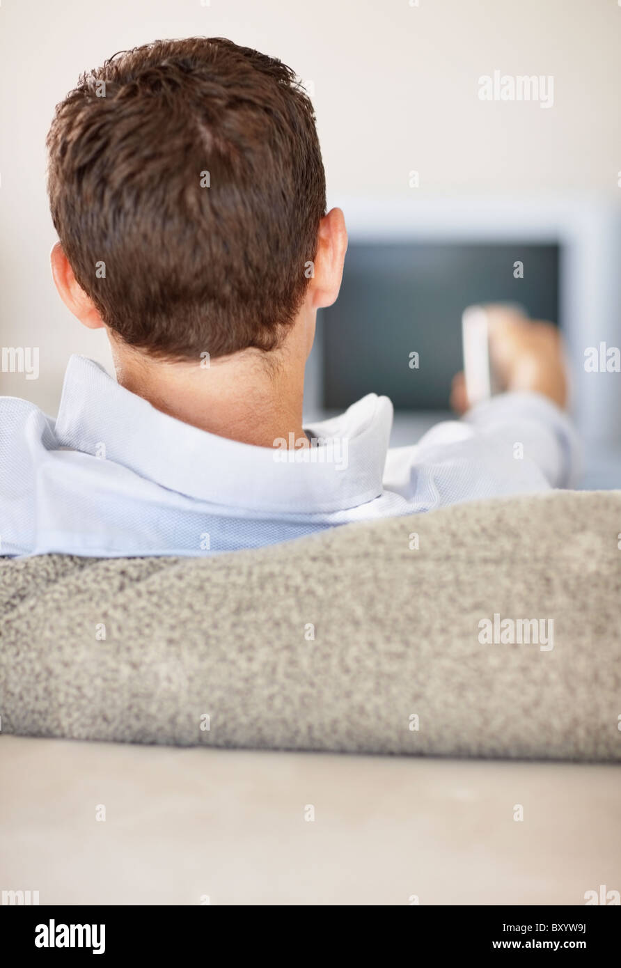 Mid adult man in front of television, changing channels Stock Photo - Alamy